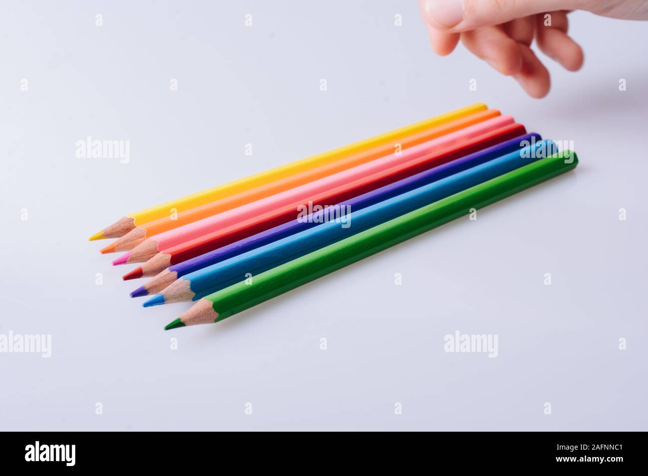 Hand holding color Pencils placed on a white background Stock Photo - Alamy