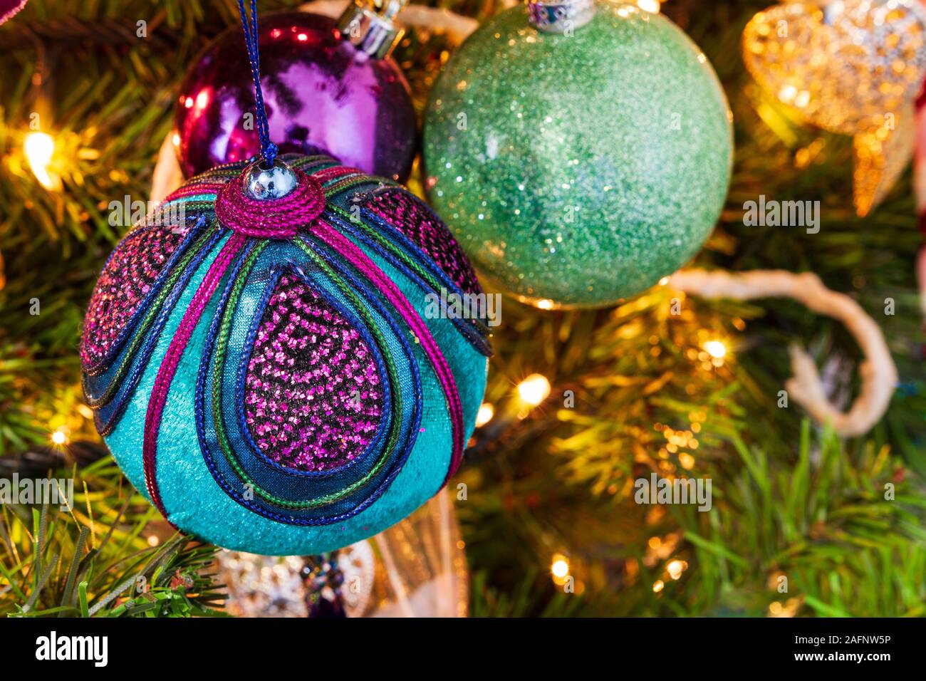 Christmas Tree decorated in a purple and cyan theme. Decorative balls ...