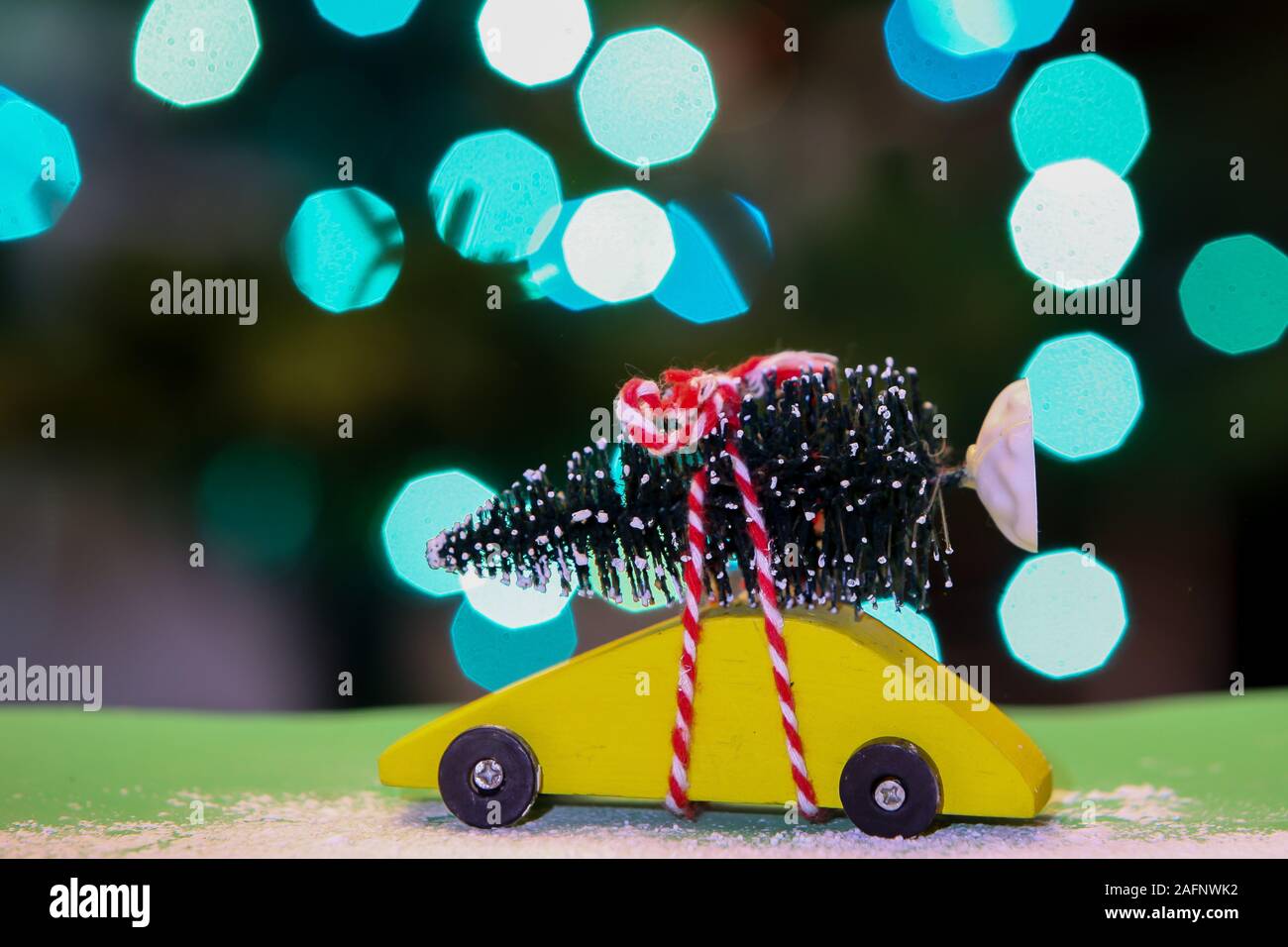 Yellow car with Christmas tree and lights in back Stock Photo - Alamy