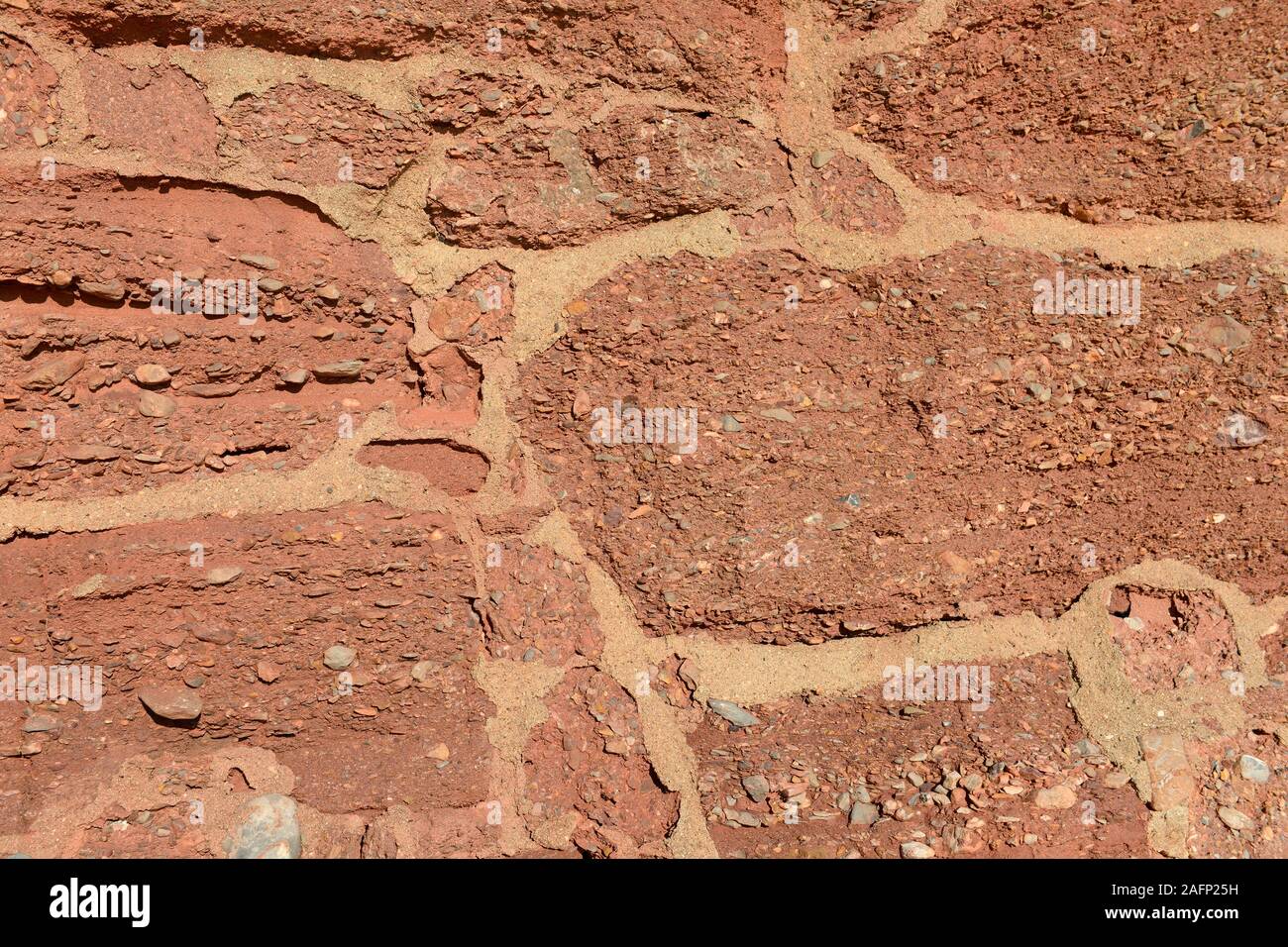 Rocks of clay and pebbles form part of a wall at Paignton in Devon ...