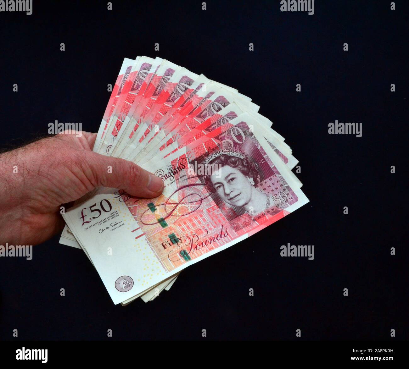 Hand holding british banknotes hi-res stock photography and images - Alamy