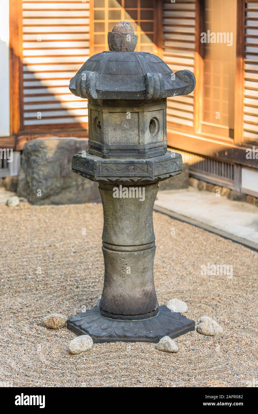 Japanese stone lantern decorated with wave patterns in the stone garden ...