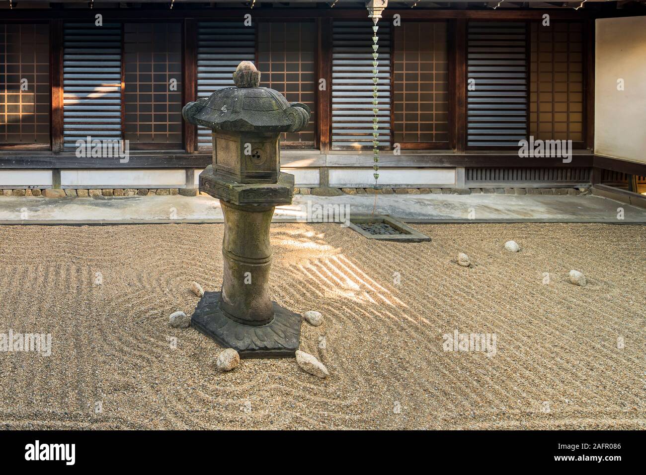 Japanese stone lantern decorated with wave patterns in the stone garden ...