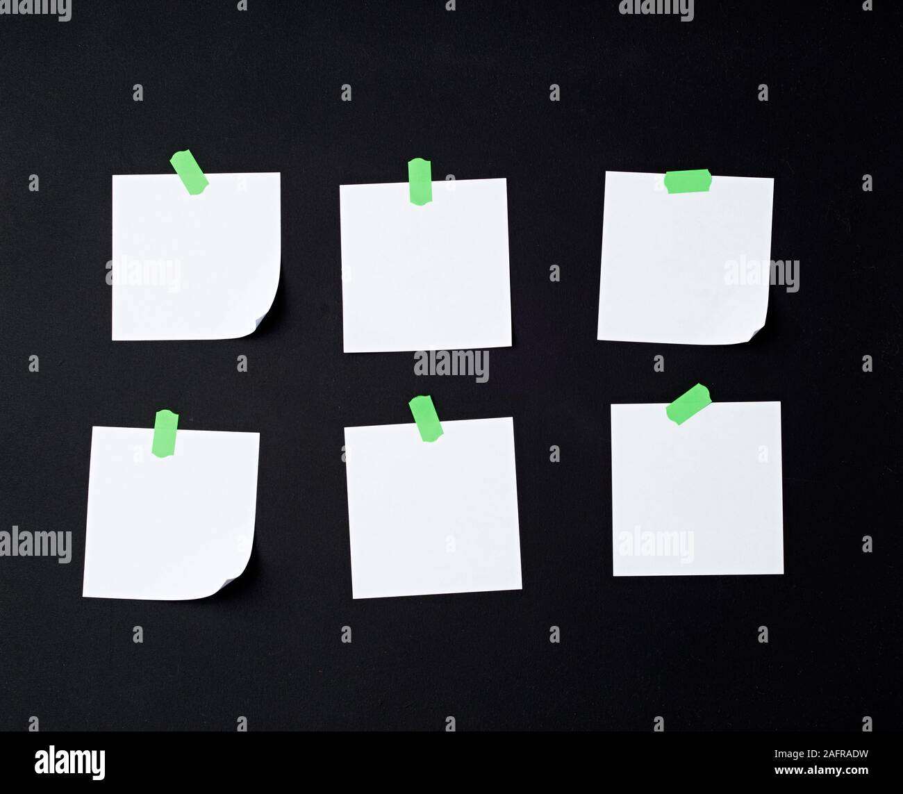 set of square white blank sheets of paper glued with green sticky paper ...