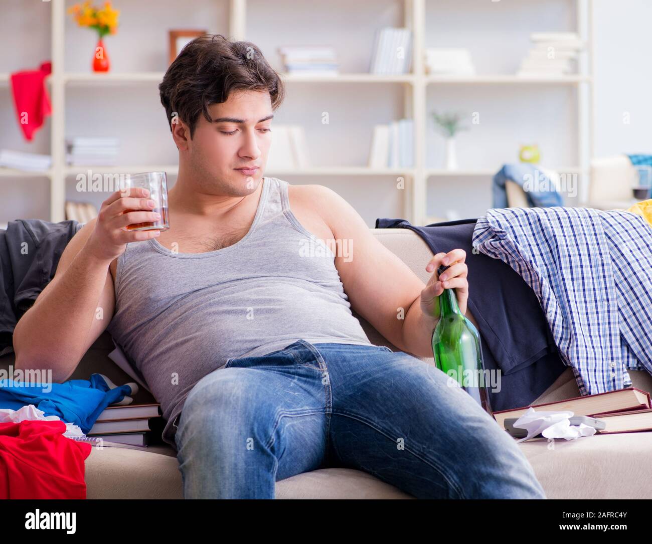 The young man student drunk drinking alcohol in a messy room Stock ...