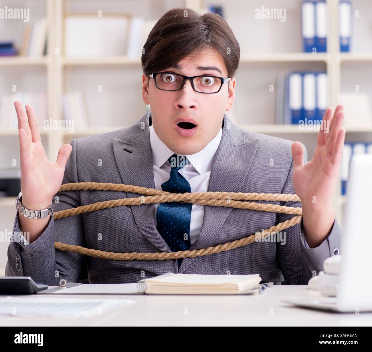 The businessman tied up with rope in office Stock Photo - Alamy