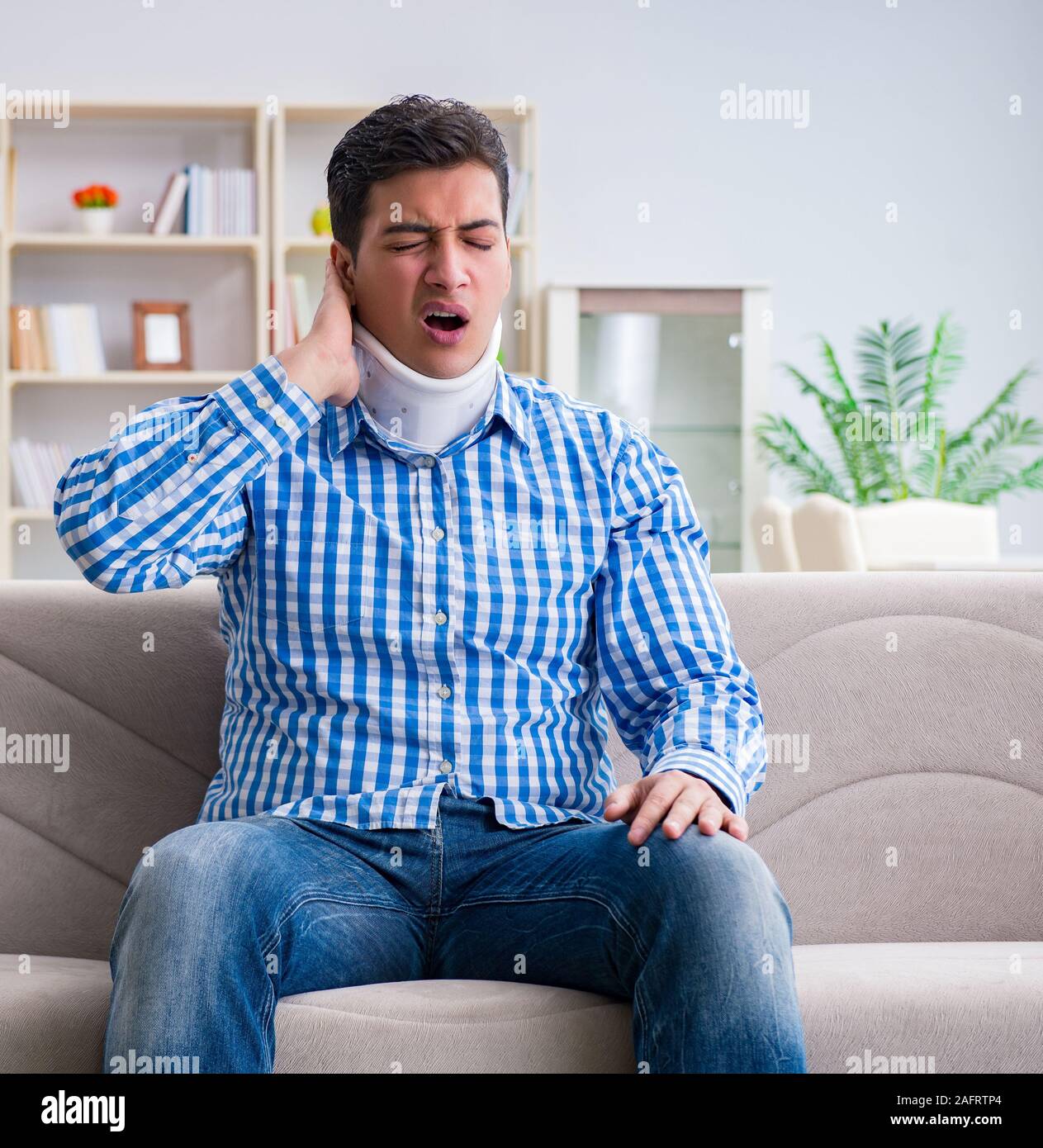 Young man suffering a neck spine head trauma wearing a cervical collar ...