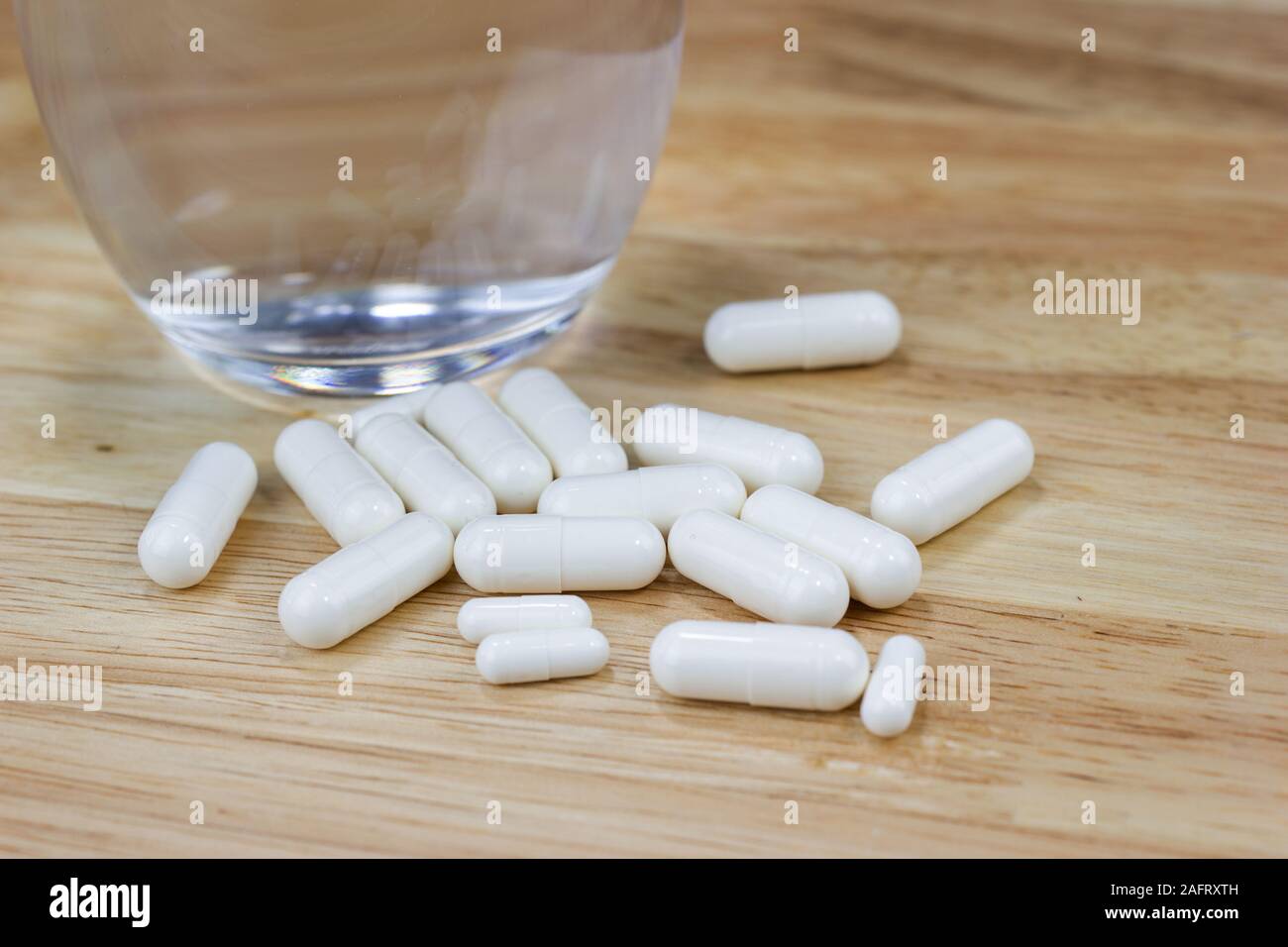 the white many capsules on wood table Stock Photo - Alamy