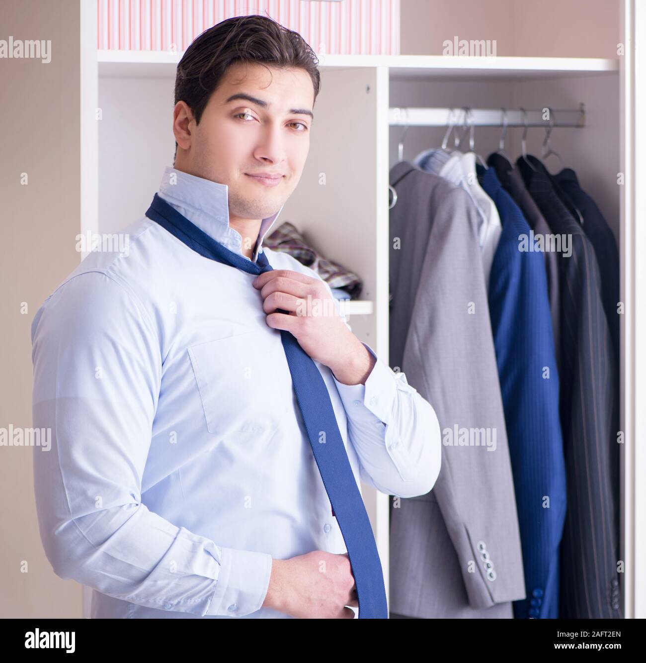 The young man businessman getting dressed for work Stock Photo - Alamy