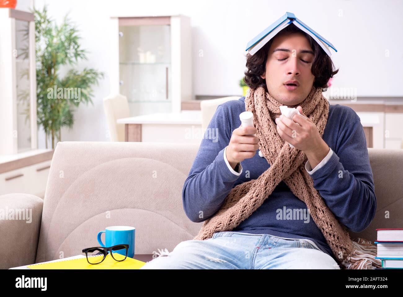 The sick male student suffering at home Stock Photo - Alamy