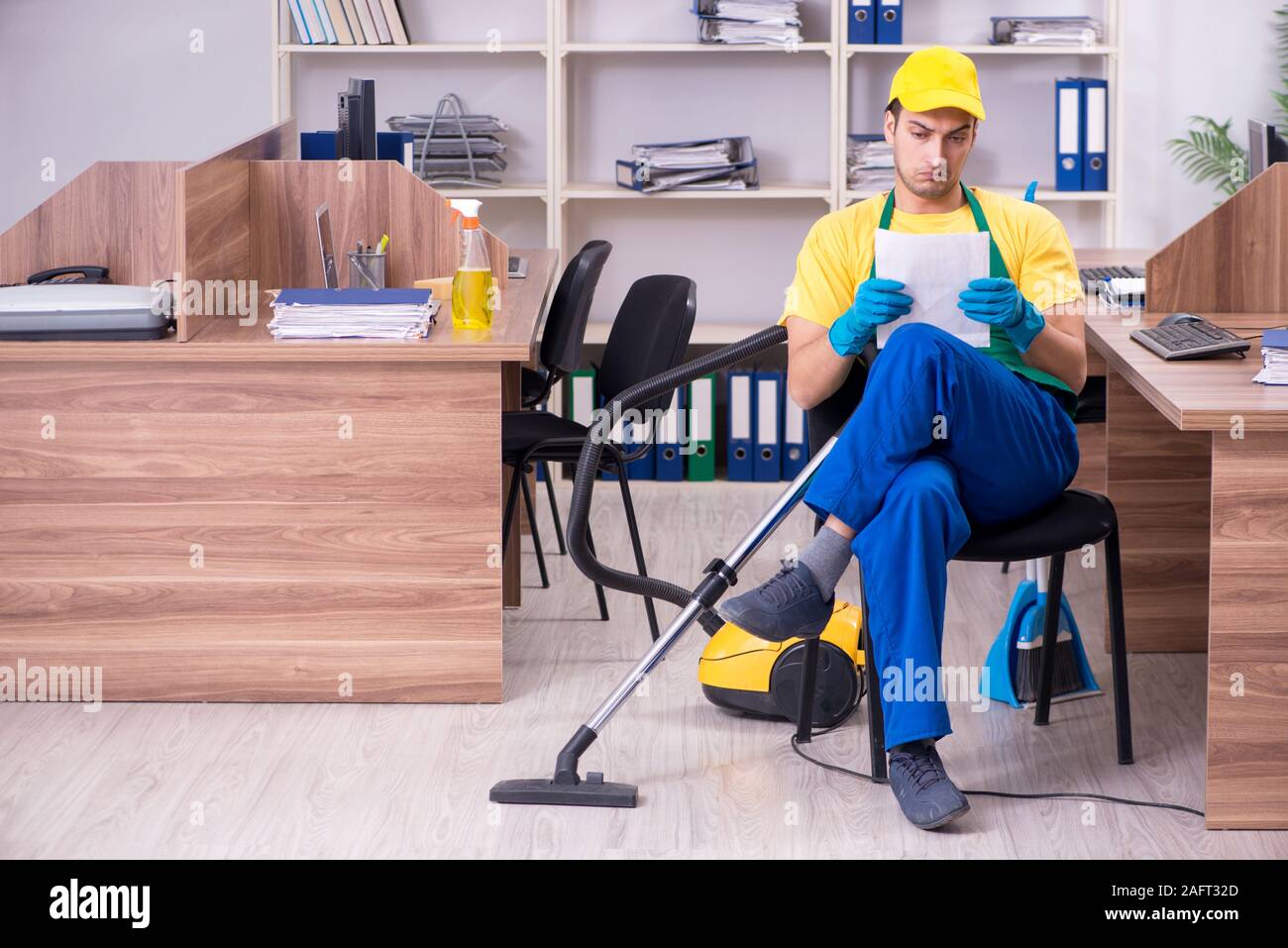 The young male contractor cleaning the office Stock Photo - Alamy