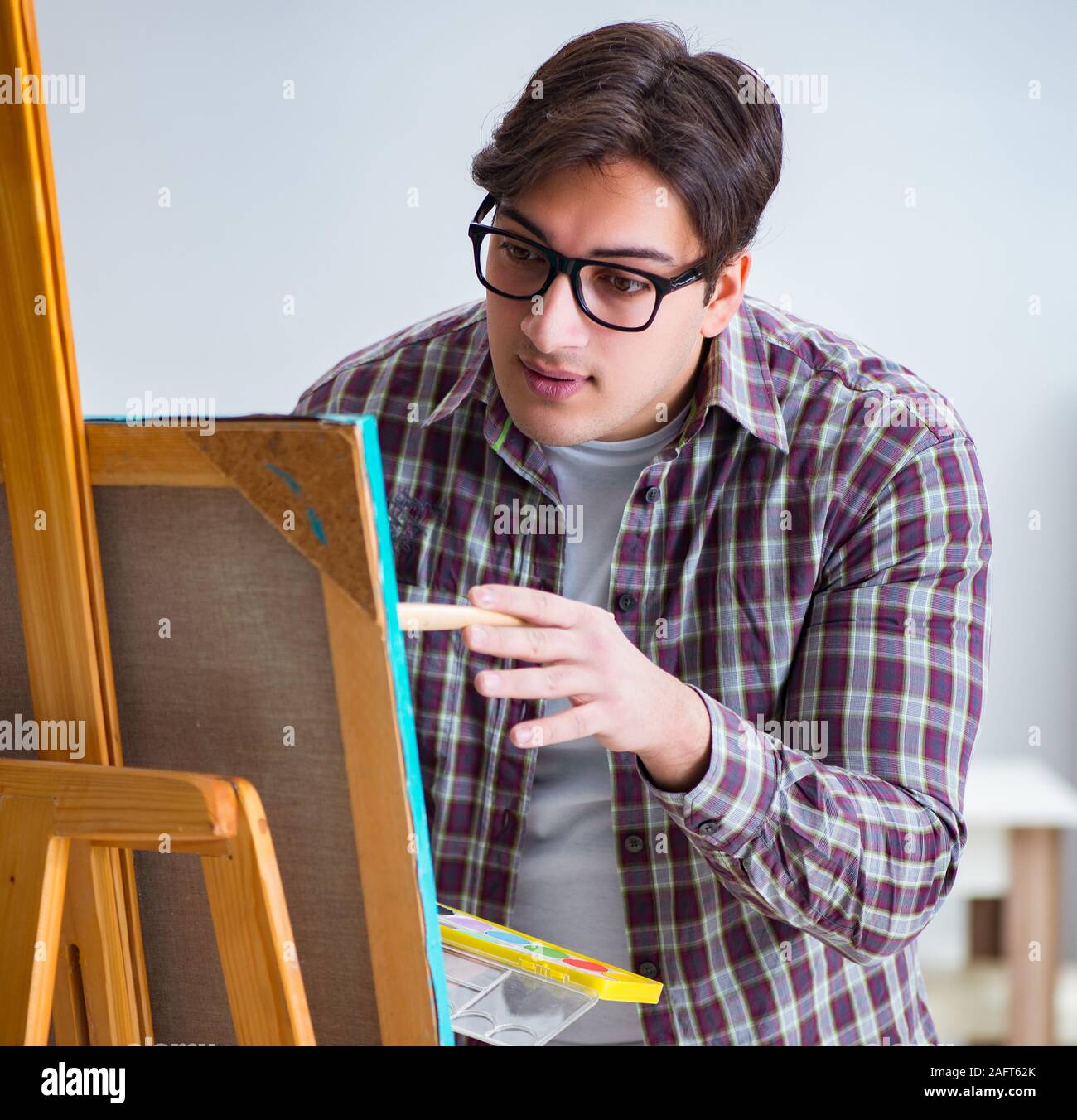 The young male artist drawing pictures in bright studio Stock Photo - Alamy