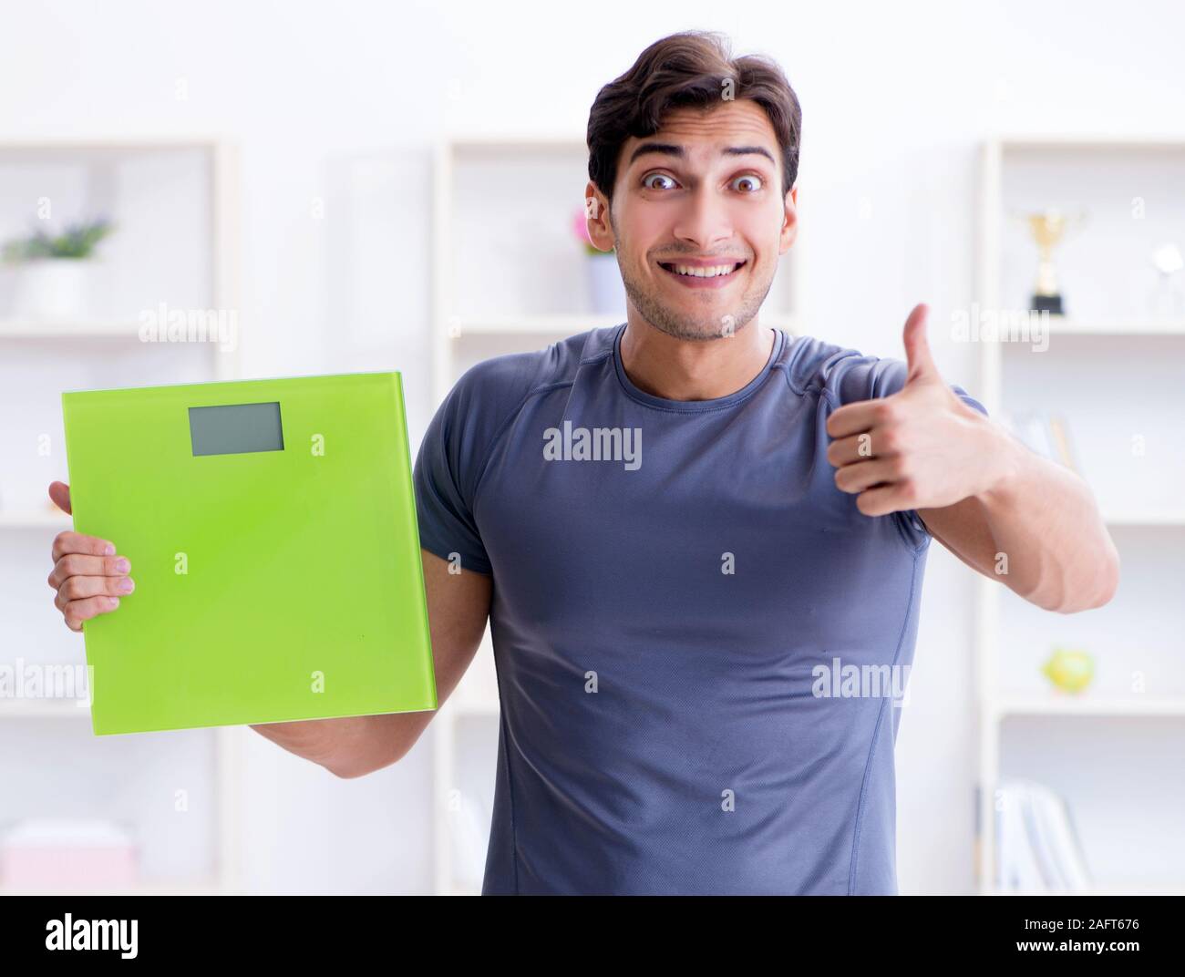 The man with scales in sports and health concept Stock Photo - Alamy