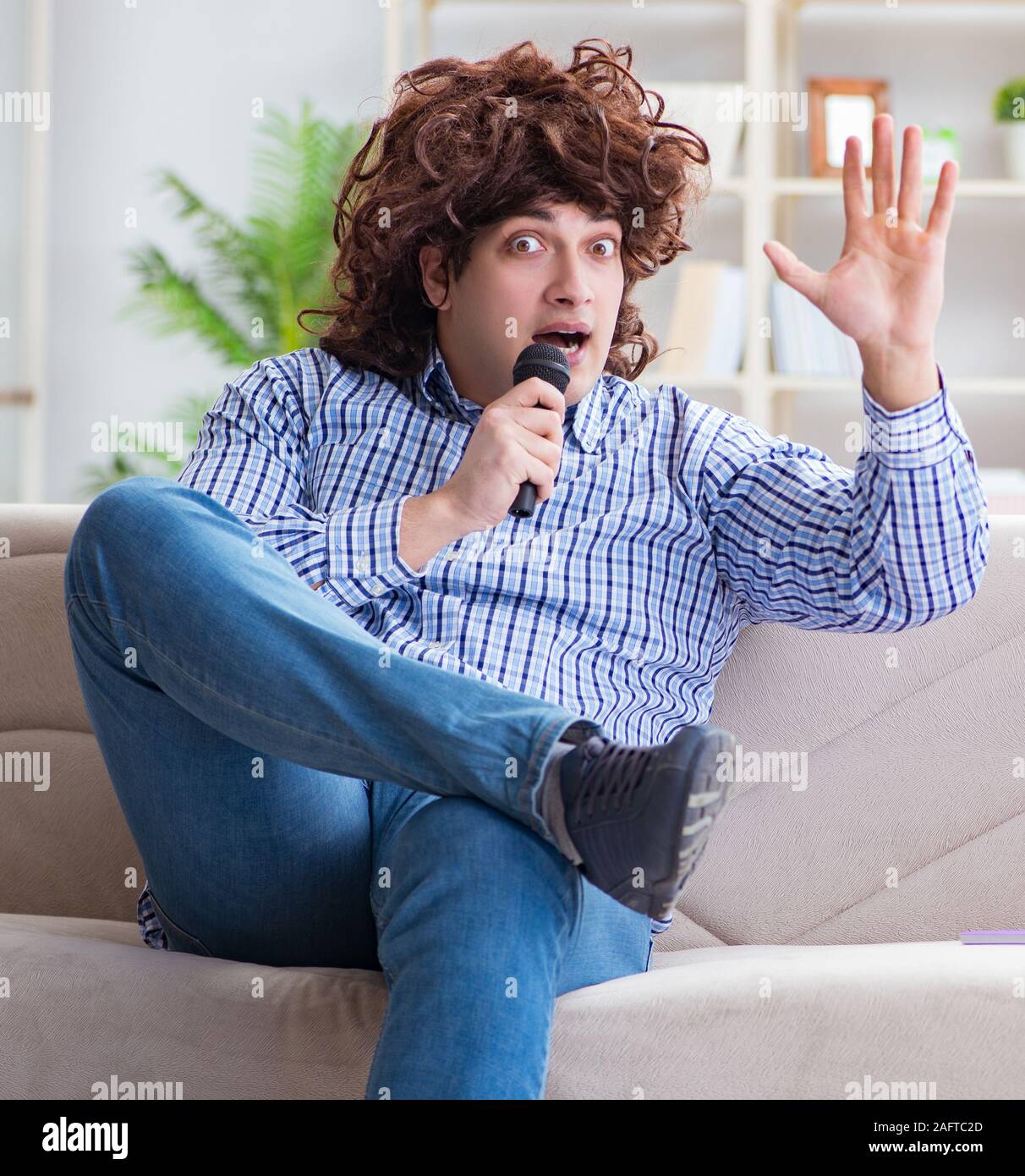 The funny man singing songs in karaoke at home Stock Photo - Alamy