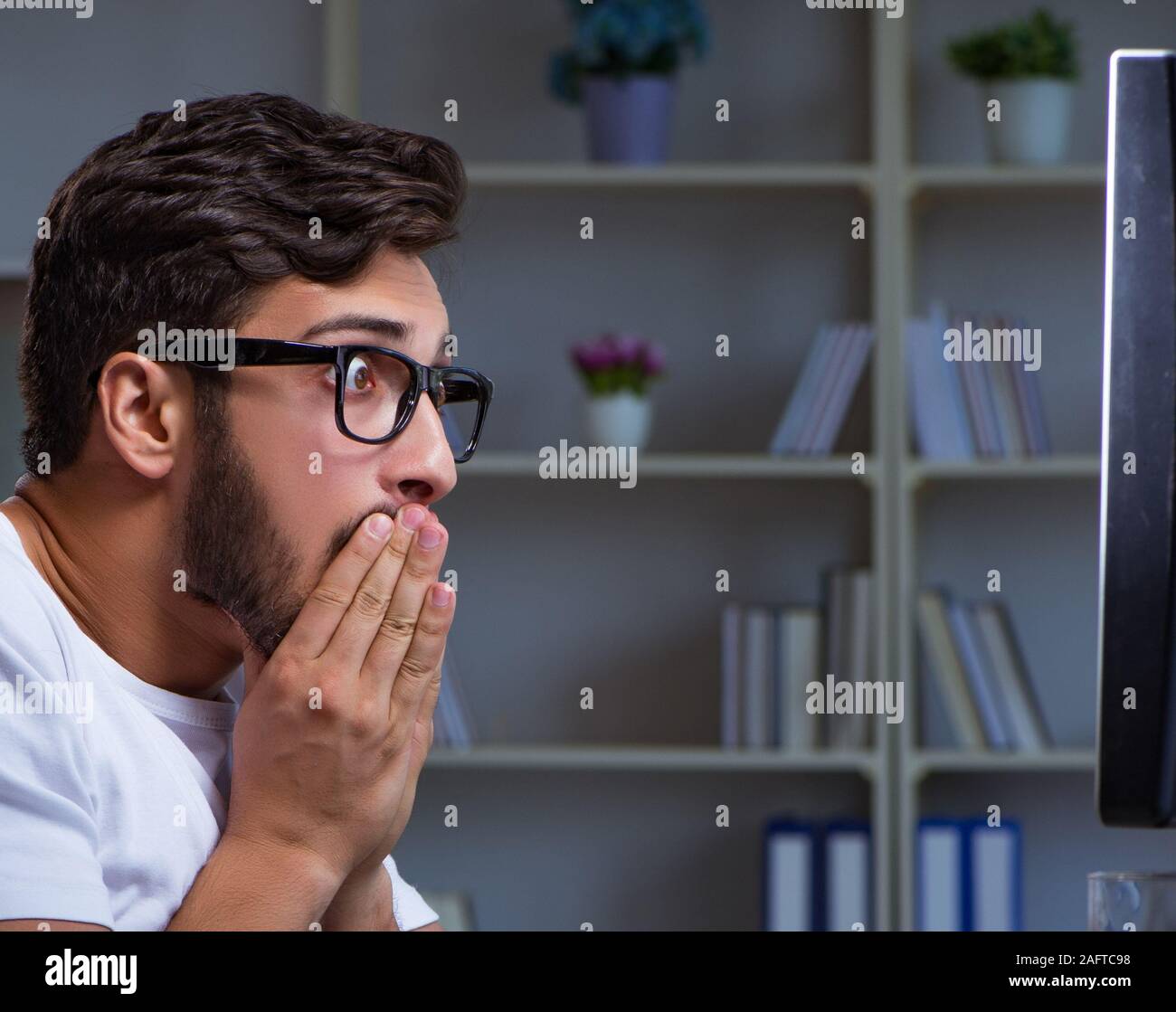 The young man staying late in office to do overtime work Stock Photo ...
