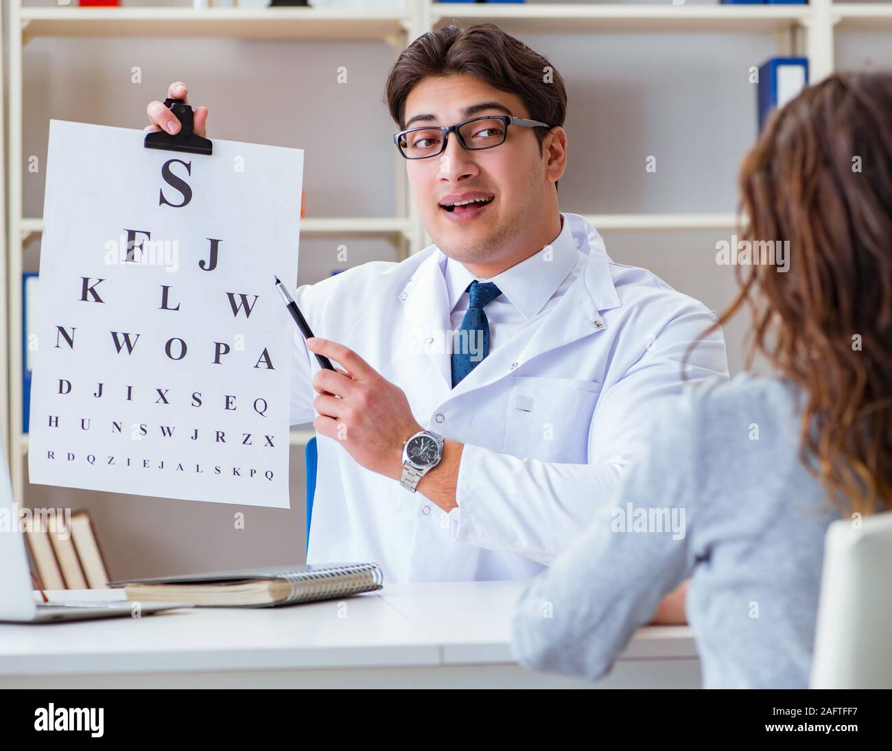 The doctor optician with letter chart conducting an eye test check ...