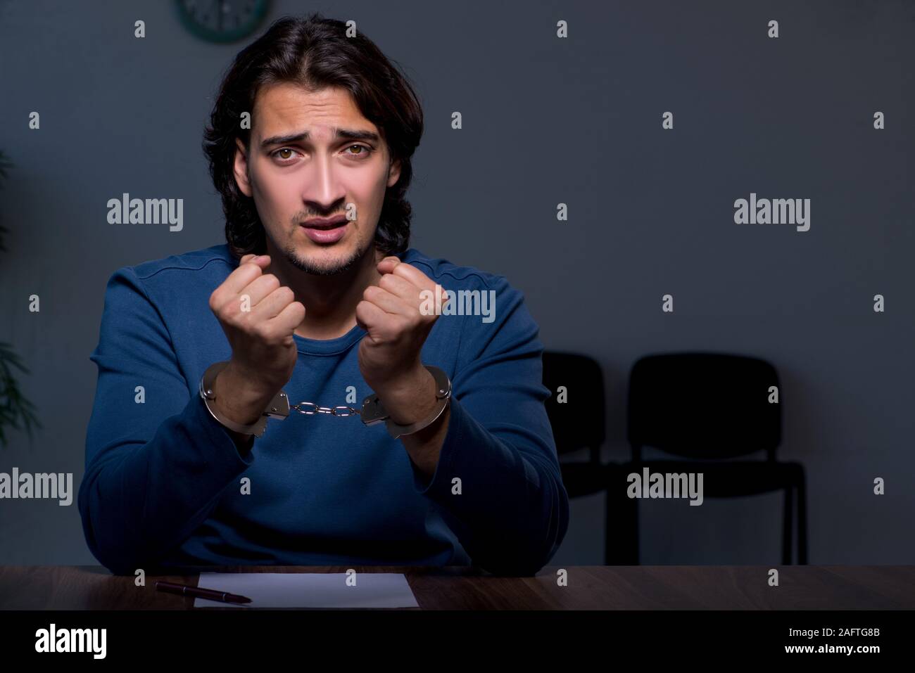 The young convict man sitting in dark room Stock Photo - Alamy