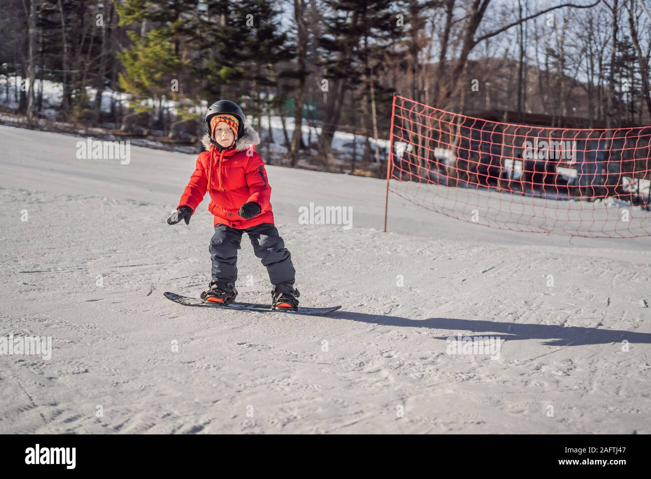 Little cute boy snowboarding. Activities for children in winter ...