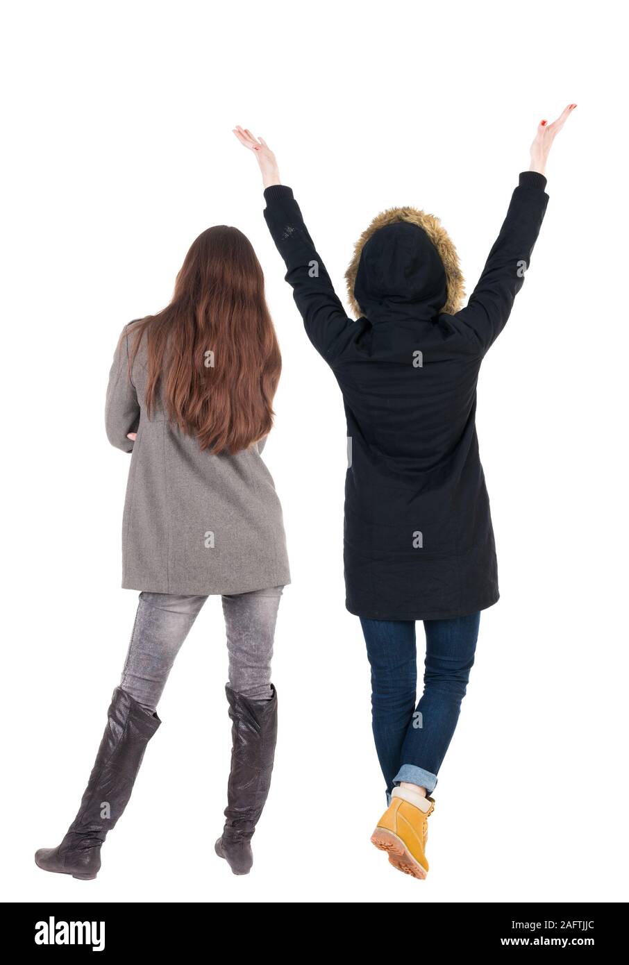 Back view of two pointing young girl in winter jacket. Rear view people ...