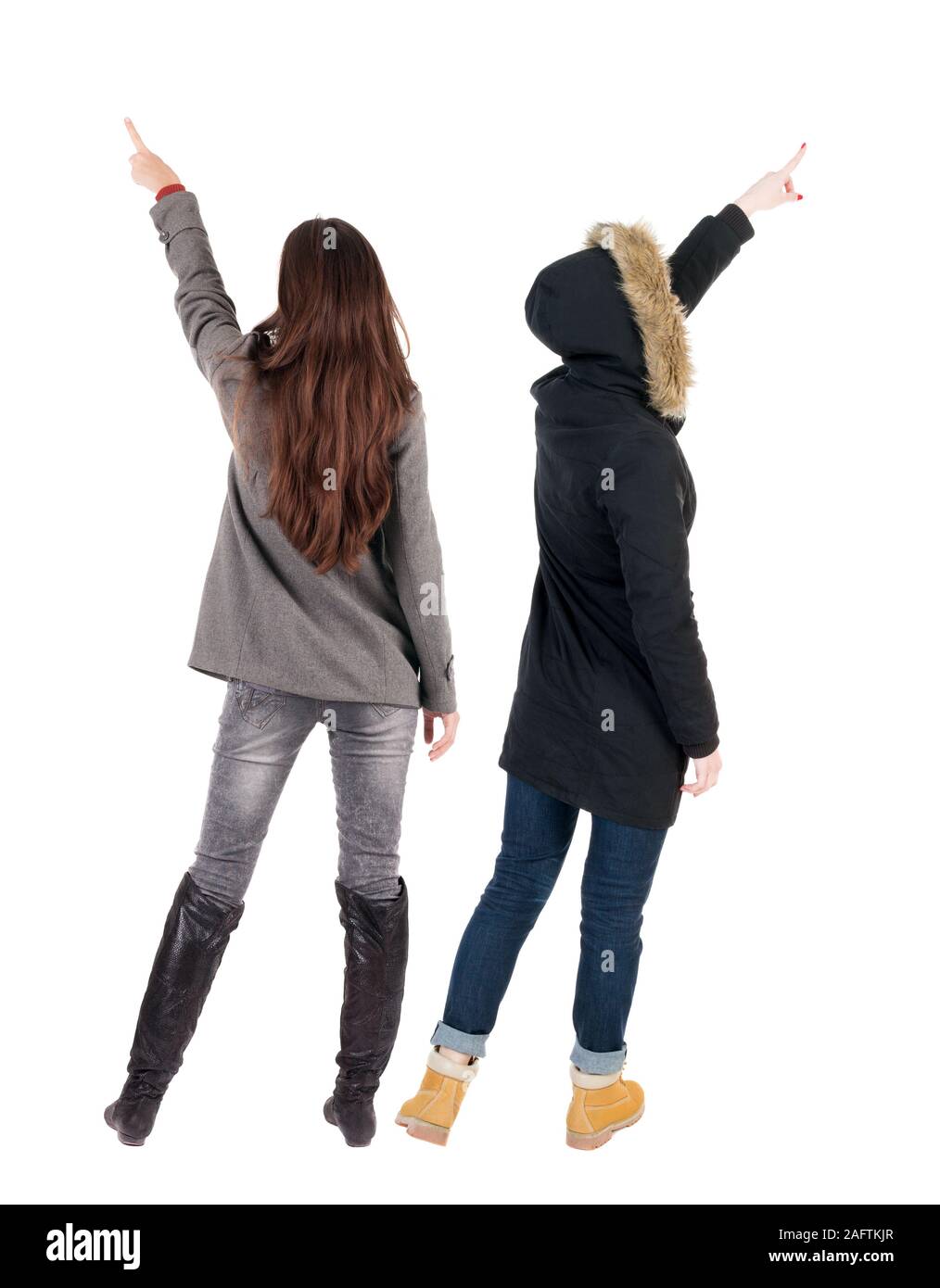 Back view of two pointing young girl in winter jacket. Rear view people ...