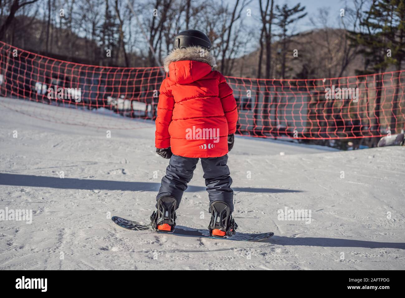 Little cute boy snowboarding. Activities for children in winter ...