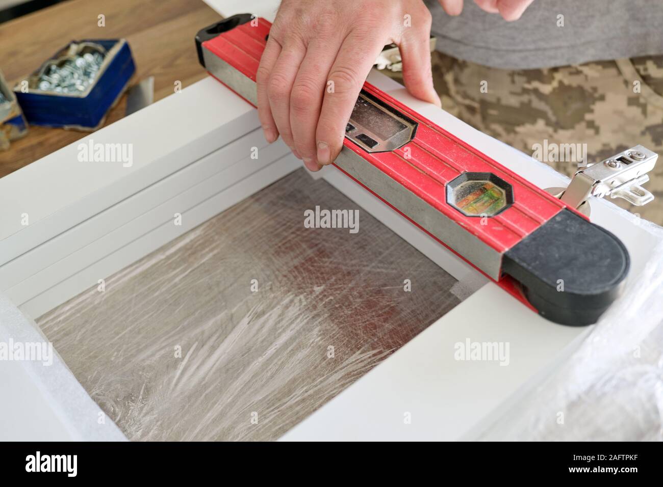 Furniture assembly. Carpenter using building level Stock Photo - Alamy