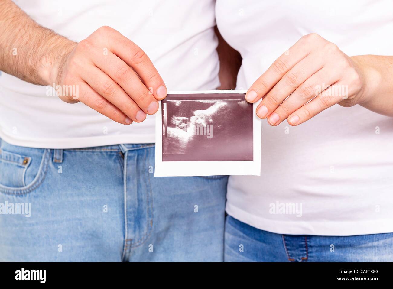 Dad and mom holding together in outstretched hands photo of their ...