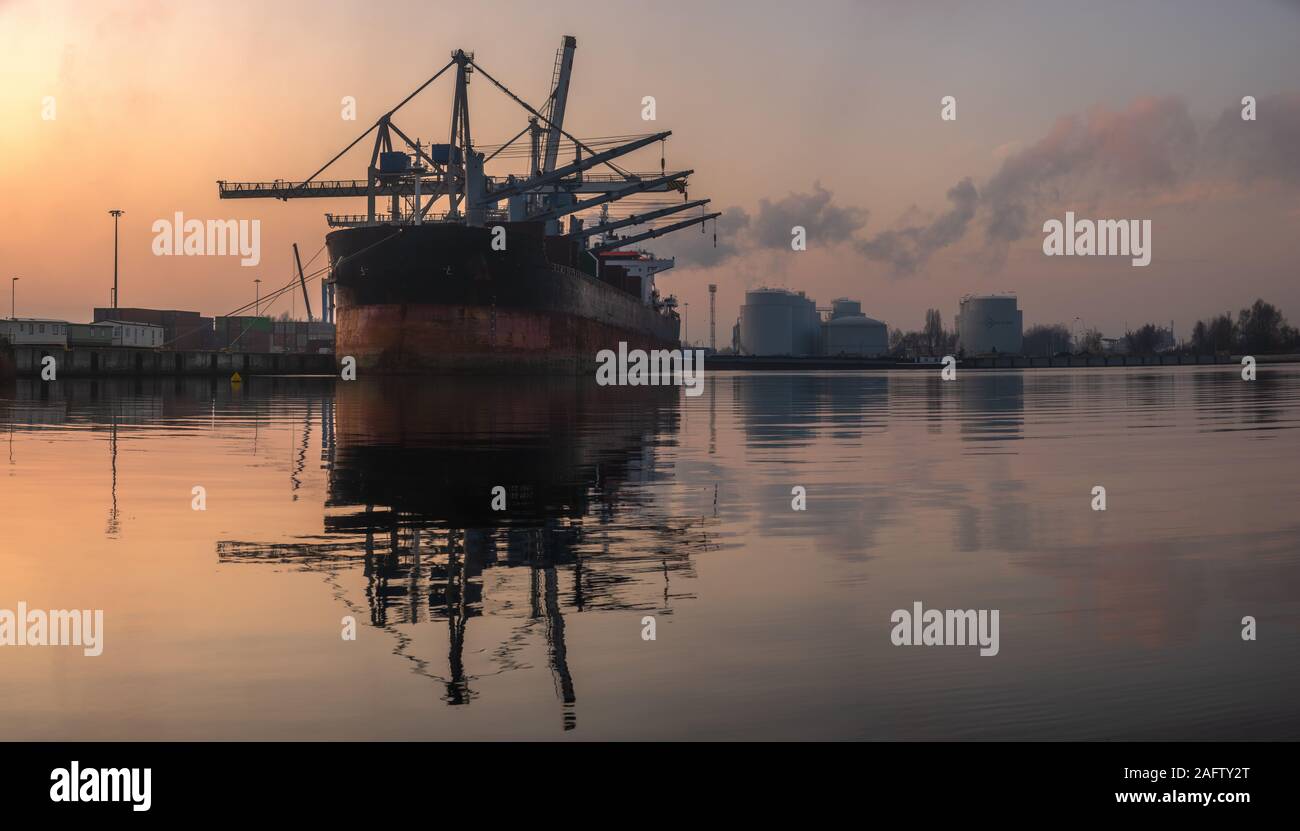 huge bulk carrier in a seaport at sunrise Stock Photo - Alamy