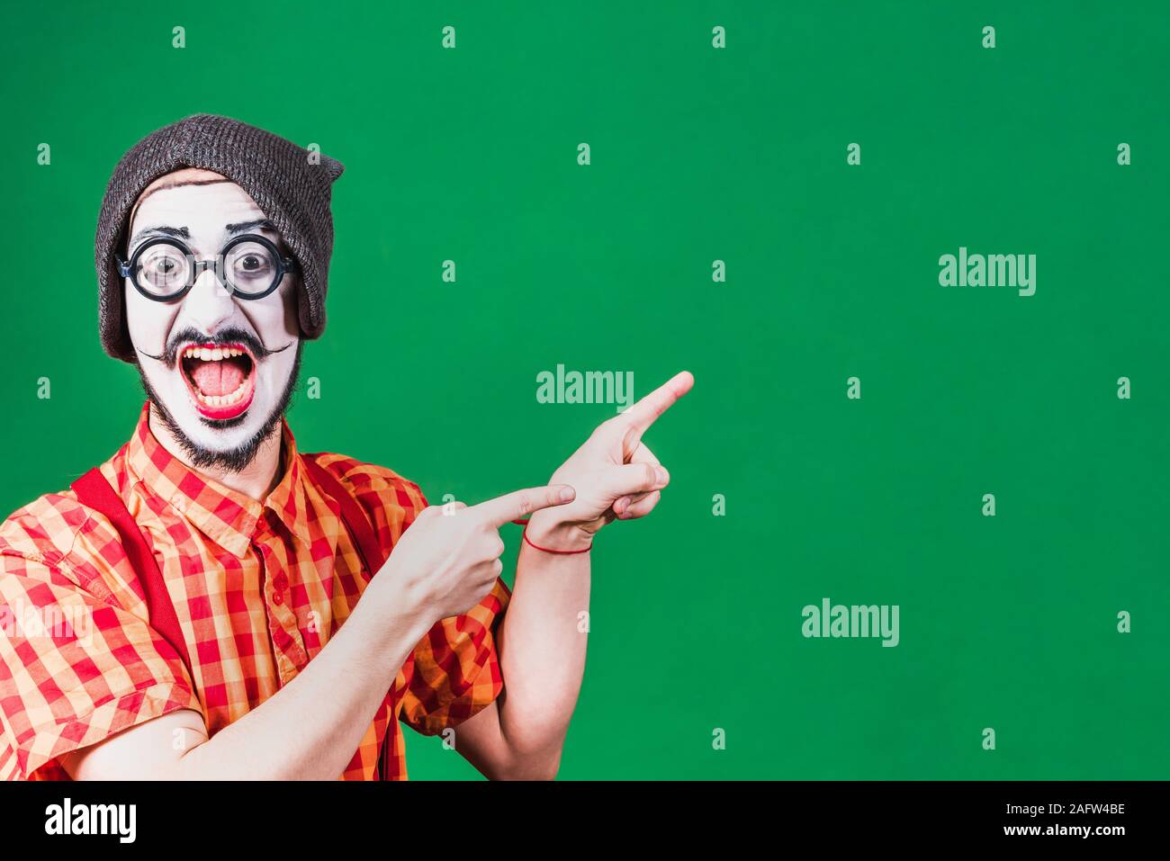 funny mime poses near a green background Stock Photo - Alamy