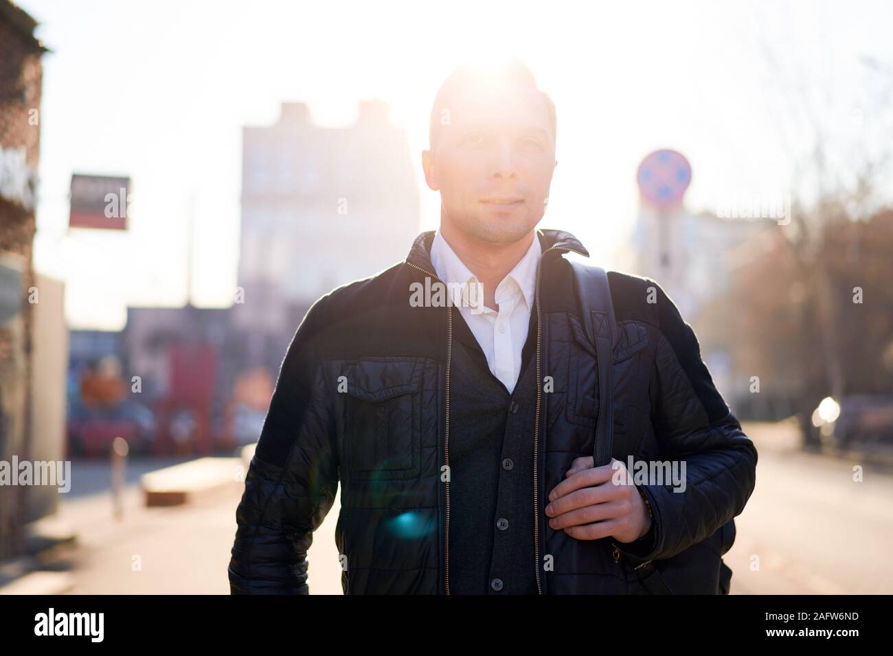 Man walking on city during day, sunlight effect Stock Photo - Alamy