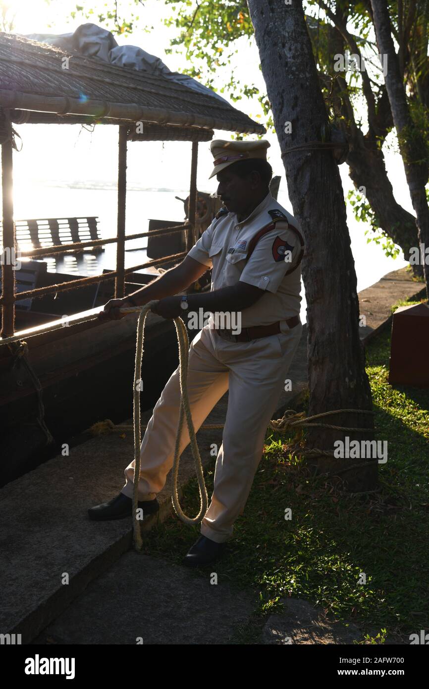 Security guard helps to control boat at Coconut Lagoon, Kerala Stock ...