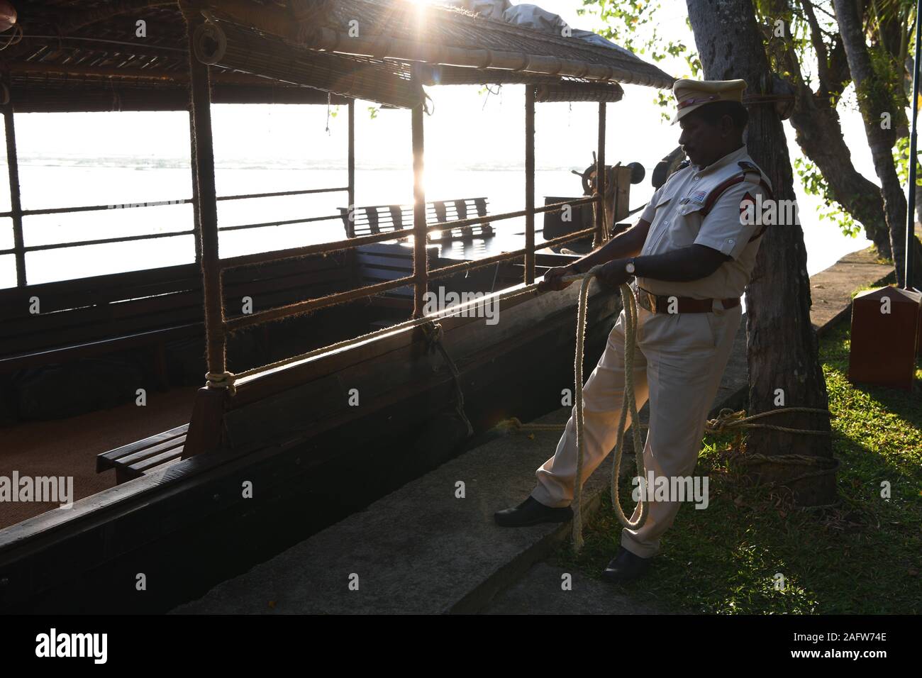 Security guard helps to control boat at Coconut Lagoon, Kerala Stock ...