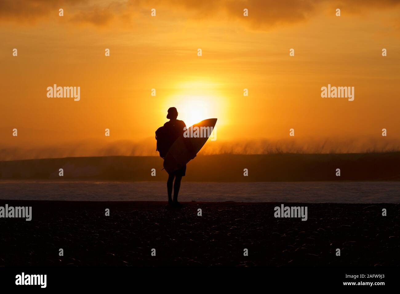 Silhouetted male surfer watching ocean wave from sunset beach Stock ... Silhouetted male surfer watching ocean wave from sunset beach Stock ...