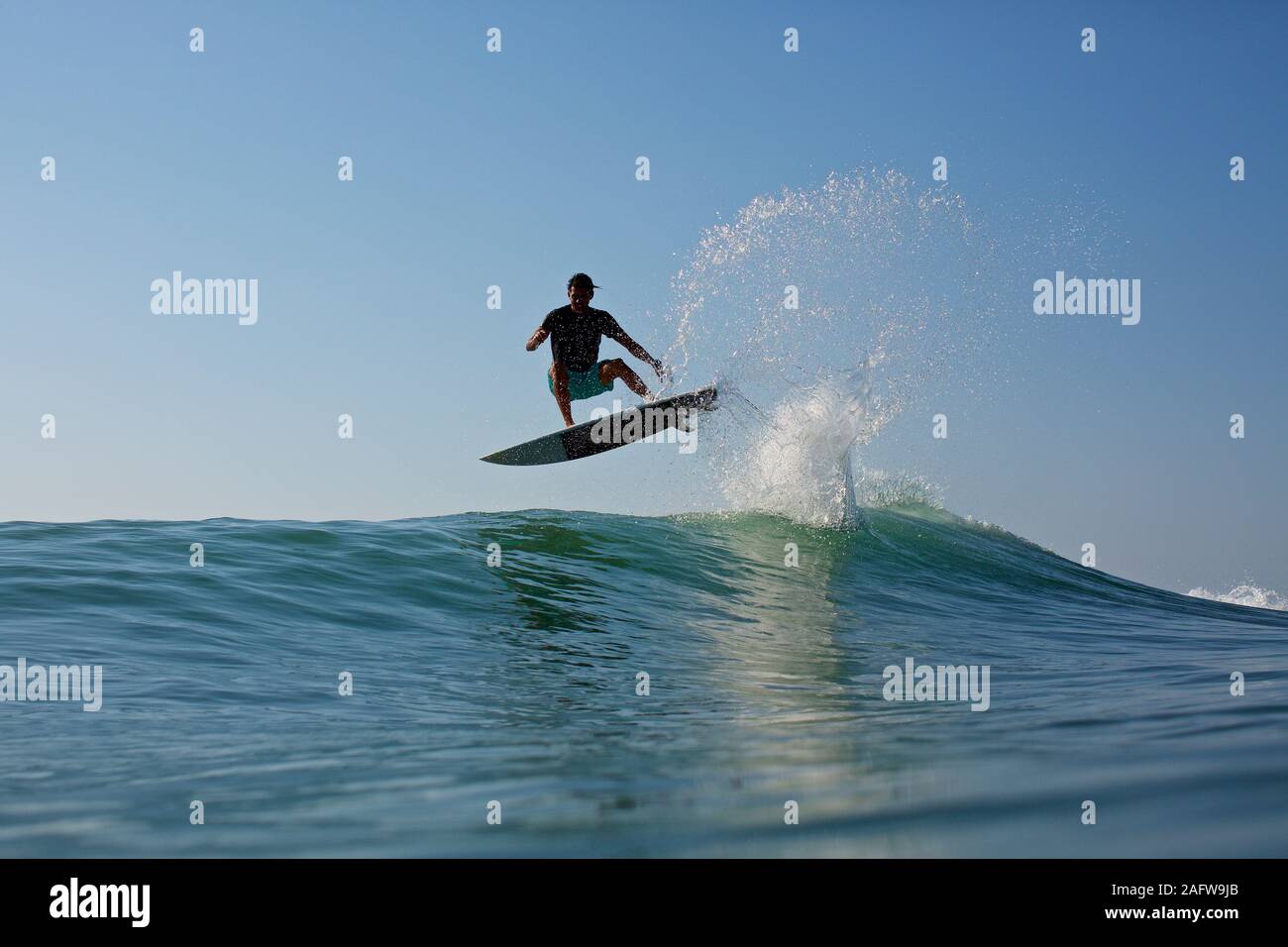 Male surfer jumping ocean wave Stock Photo - Alamy