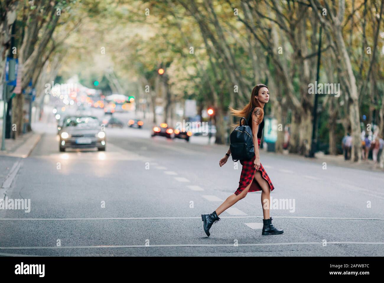 Woman crossing city street hi-res stock photography and images - Alamy