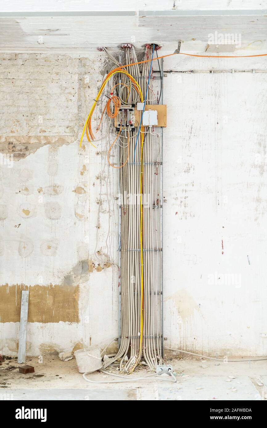 Cluster of wiring along wall at construction site Stock Photo - Alamy