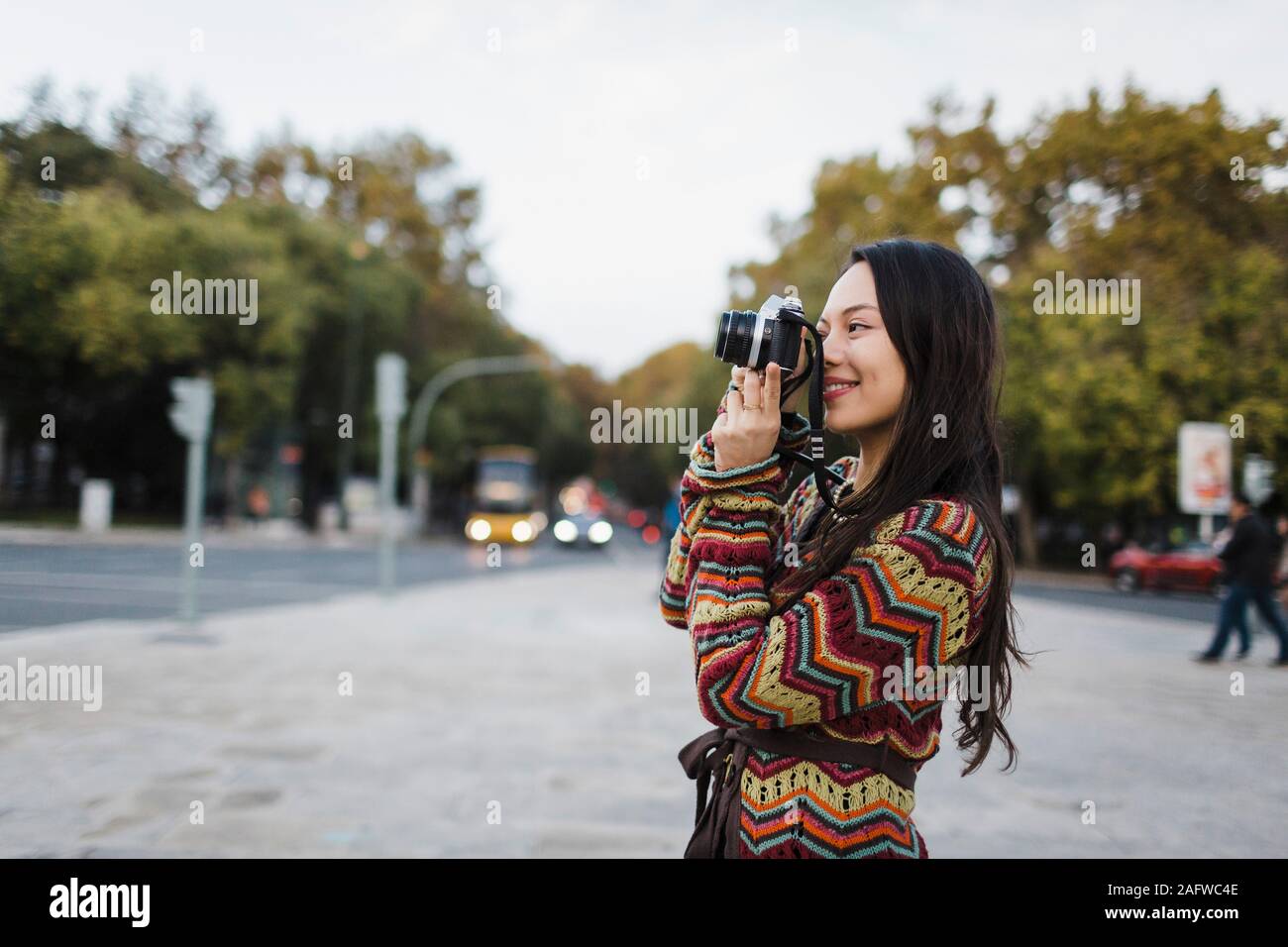 Female tourist using camera on city street Stock Photo - Alamy