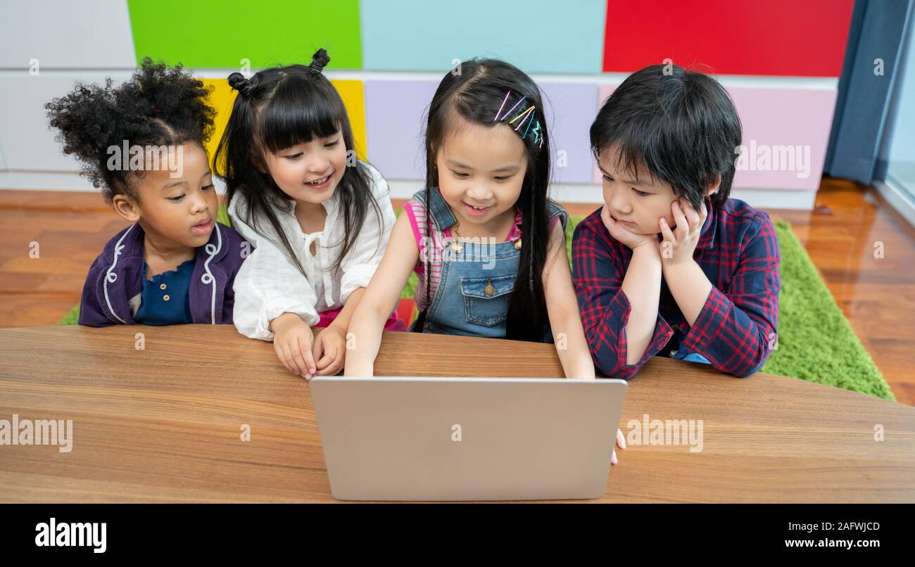 group of little children diversity watching film together on laptop ...