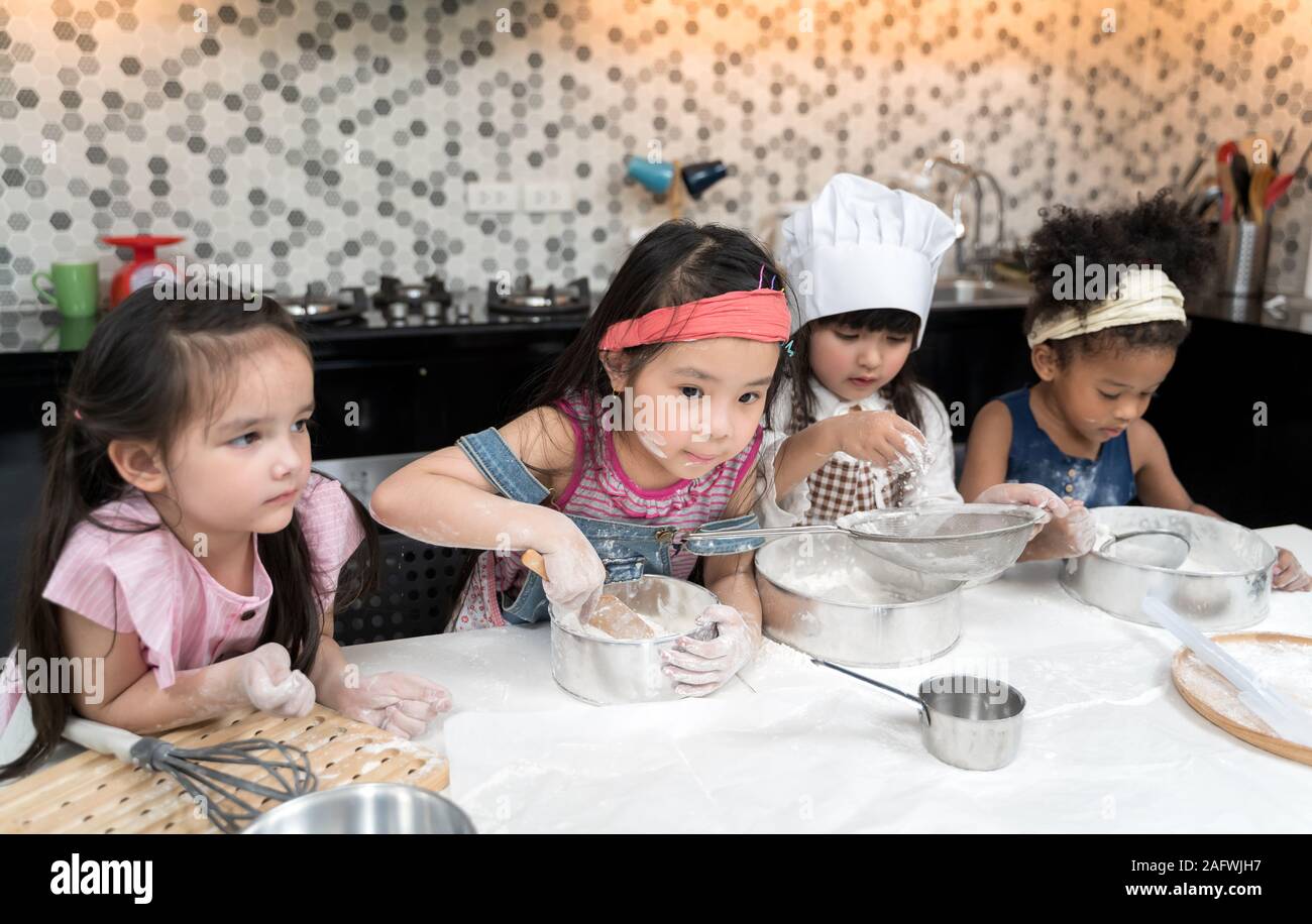 Group of kids are preparing the bakery in the kitchen .Children ...