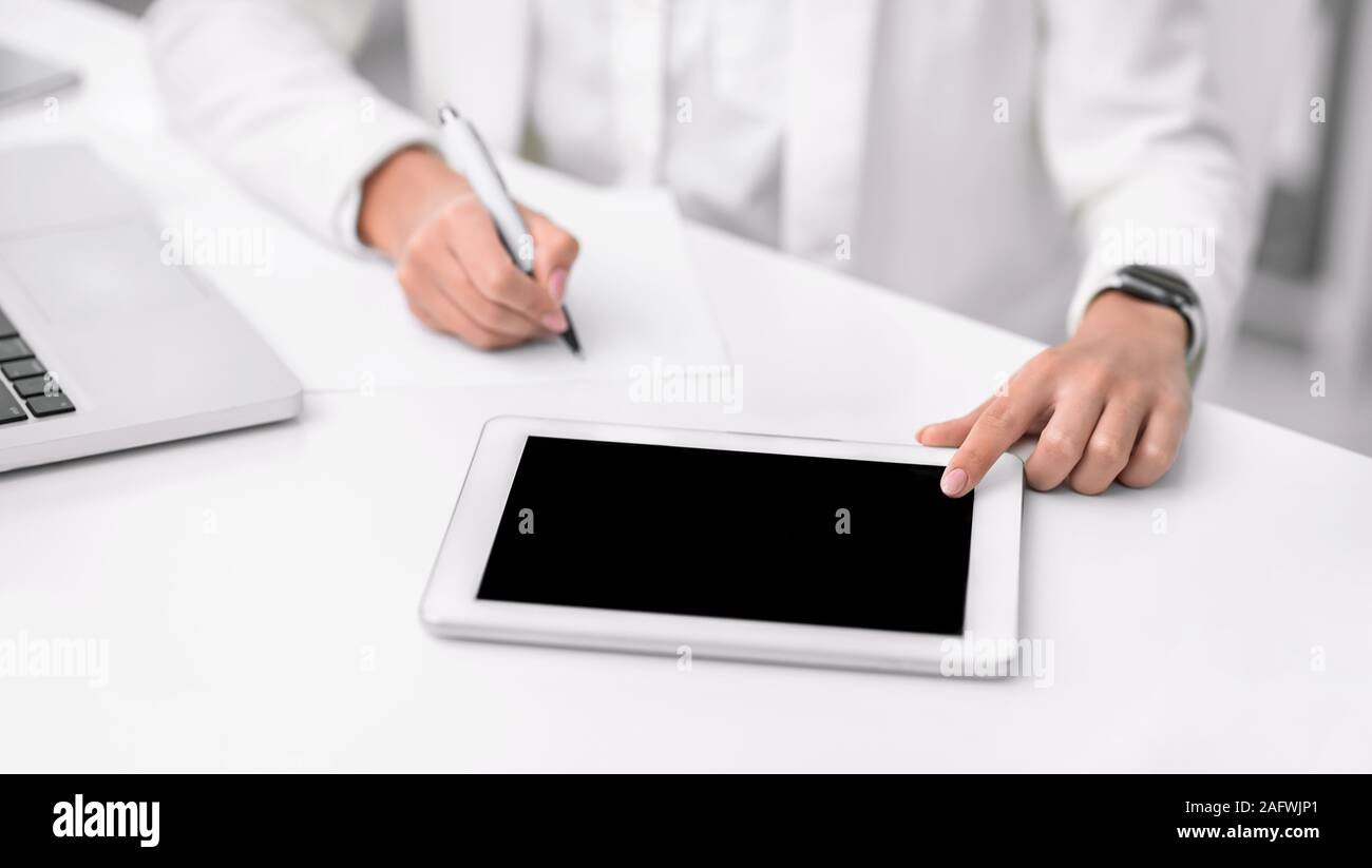 Cropped photo of girl using touchpad taking notes Stock Photo - Alamy