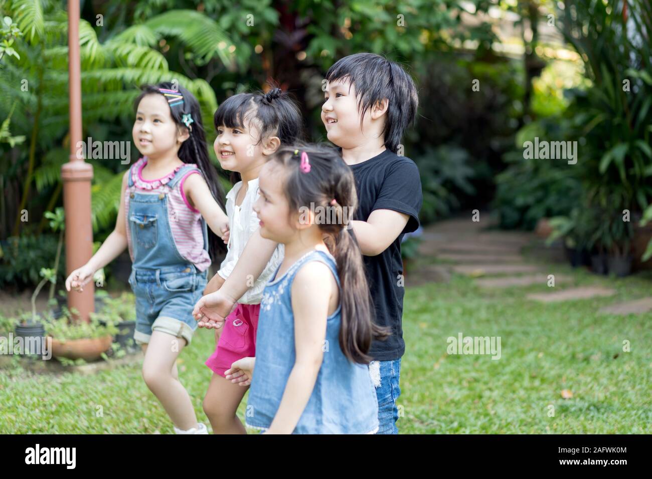 kids playing outdoors with friends. little children play at nature park ...