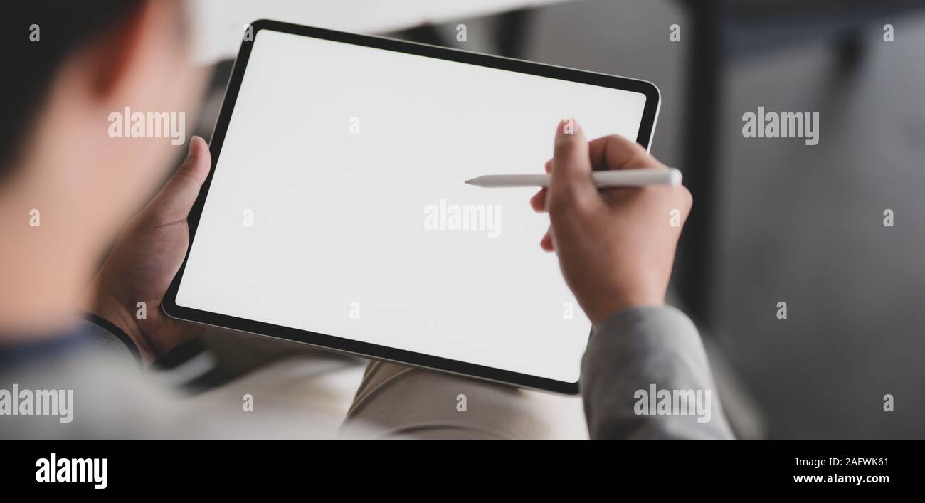 Close-up view of young businessman using blank screen tablet while ...