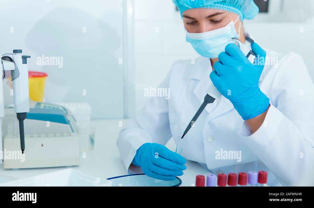 Young lab assistant collecting blood samples from big pipette Stock ...
