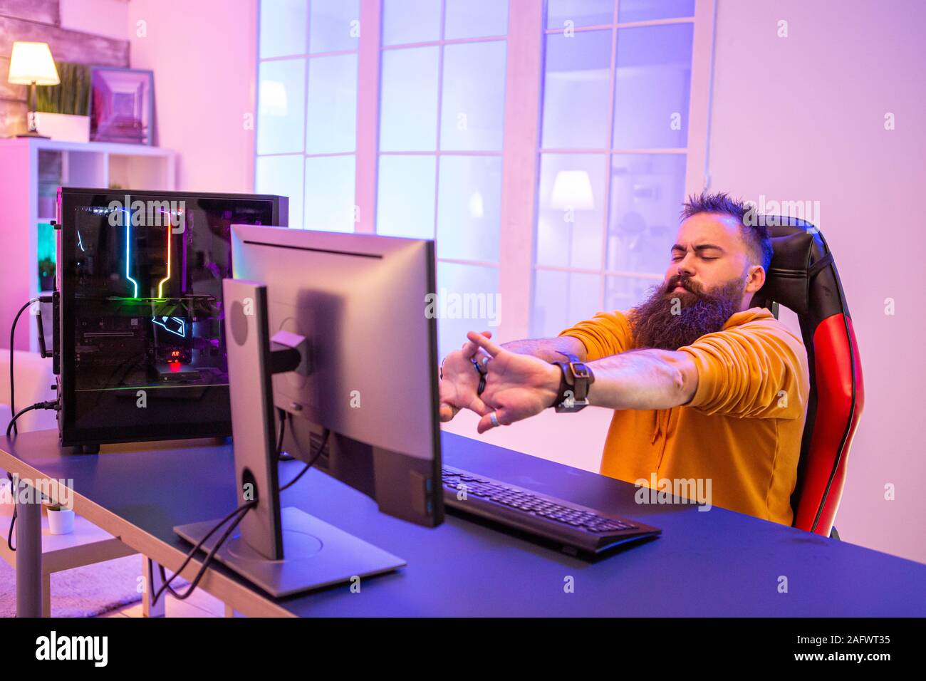 Professional gamer with long beard in front of powerful gaming rig in ...