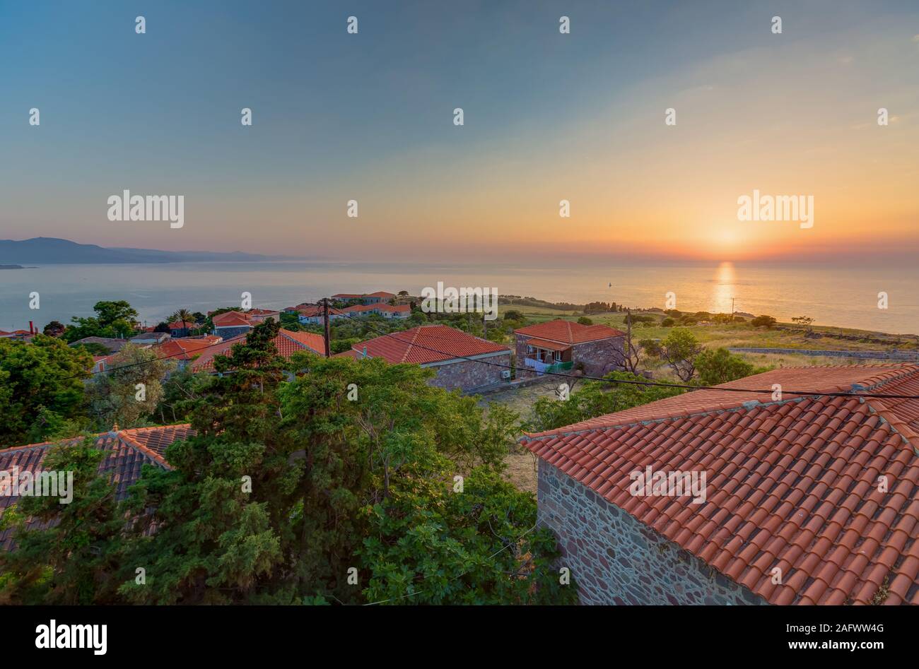 Aerial shot of the beautiful houses by the ocean under the sunset ...