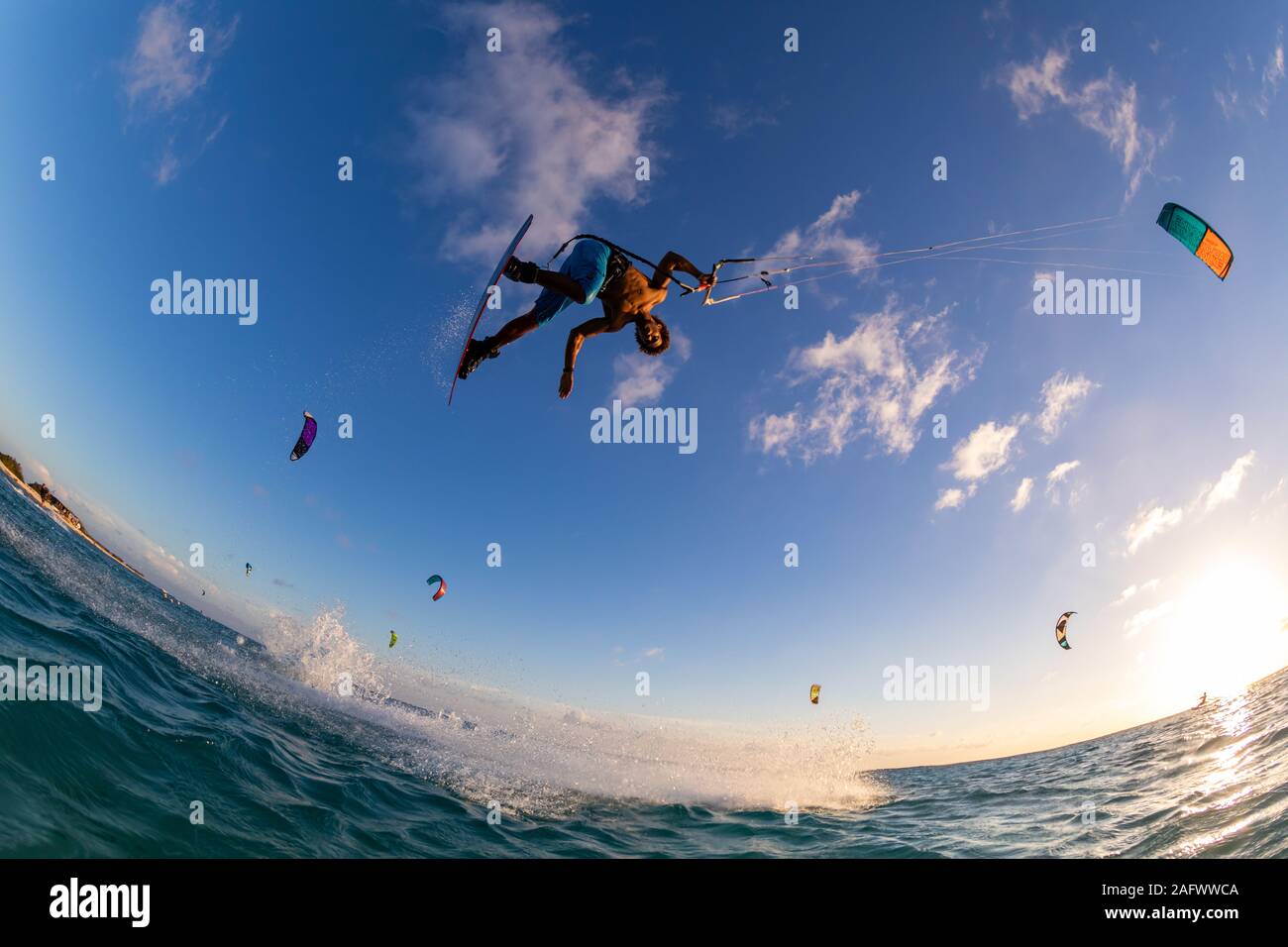 Low angle shot of a person surfing and flying a parachute at the same ...