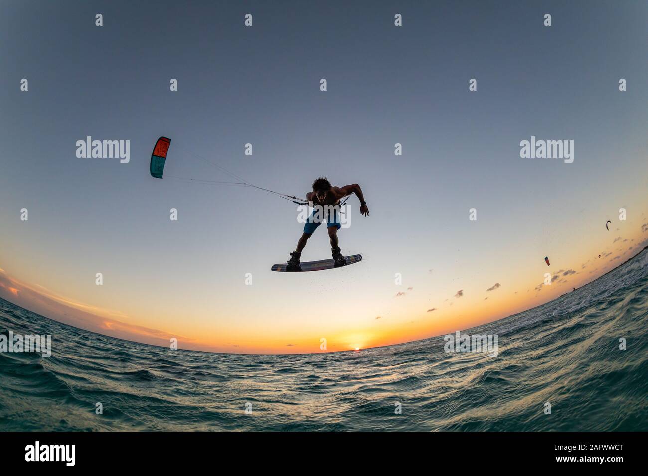 Person surfing and flying a parachute at the same time in Kitesurfing ...