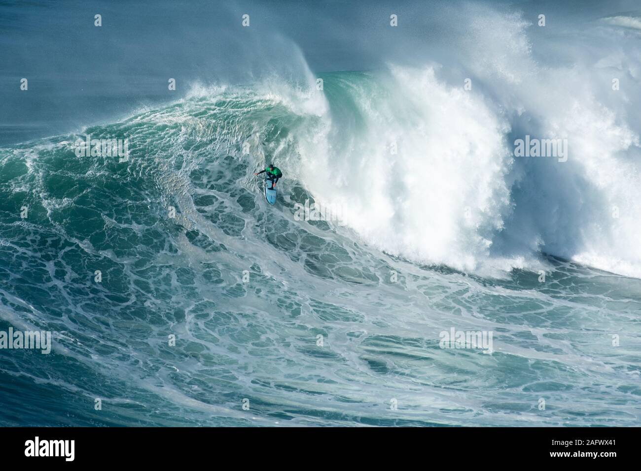 NAZARé, PORTUGAL - Dec 01, 2019: A surfer catching the tall wave of the ...