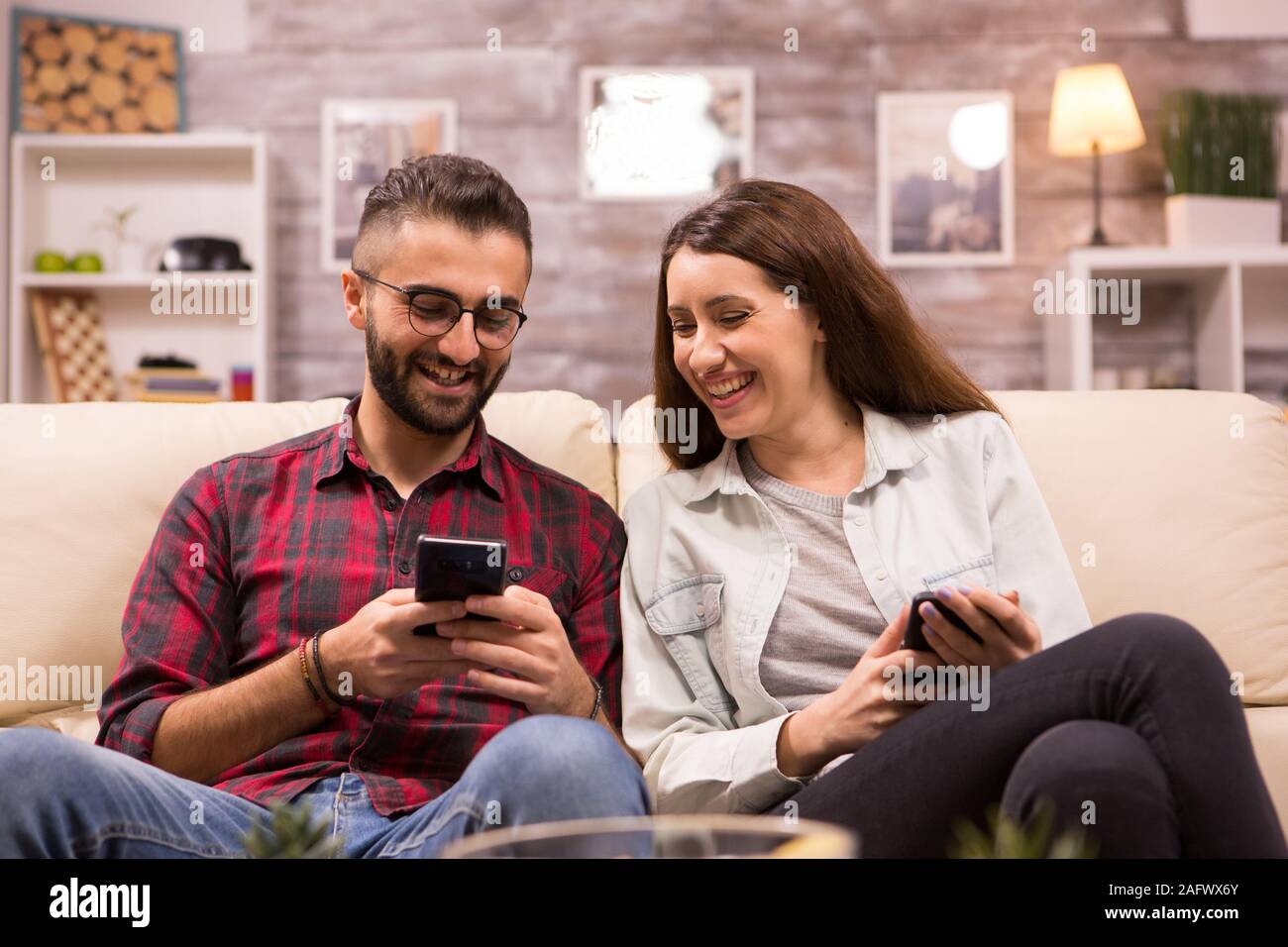 Caucasian boyfriend laughing with his girlfriend while showing her ...