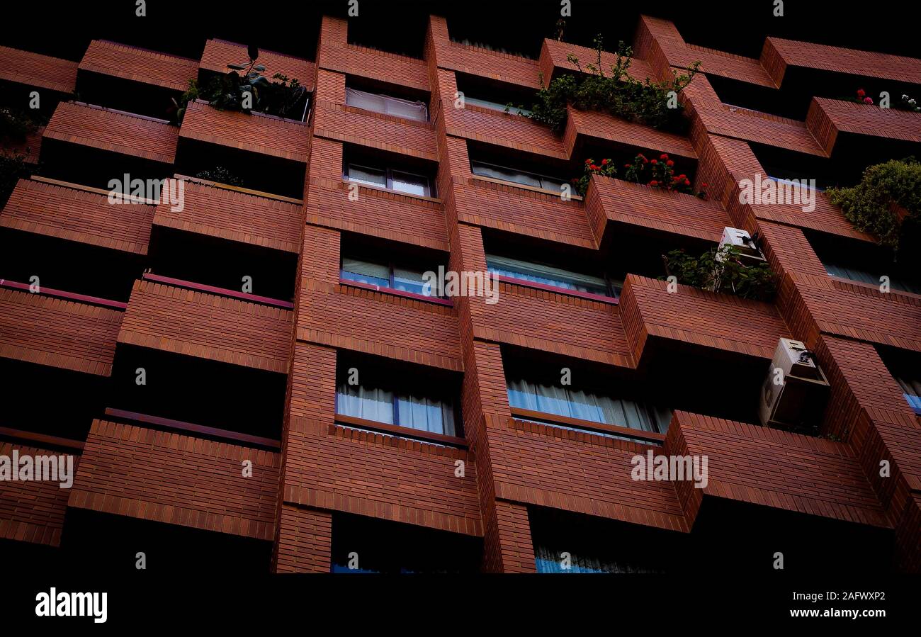 Low angle shot of a red cobblestone residential building with flowers ...